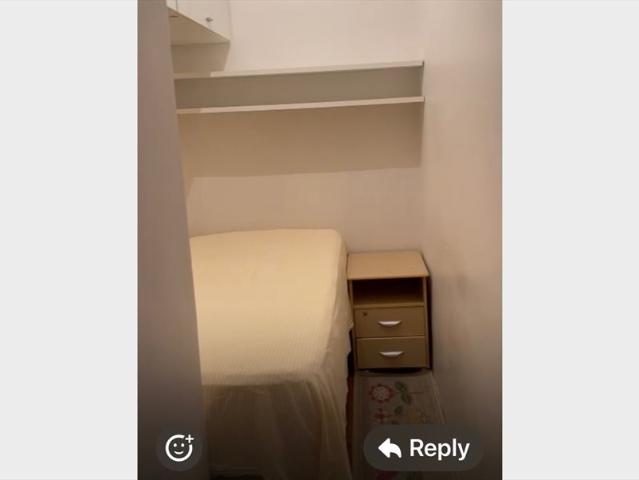 Um quarto pequeno na área de serviços, com uma cama bem confortável