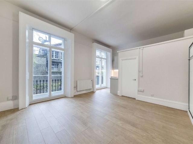 A self contained studio is on the ground floor of a white stucco fronted period building in South Kensington