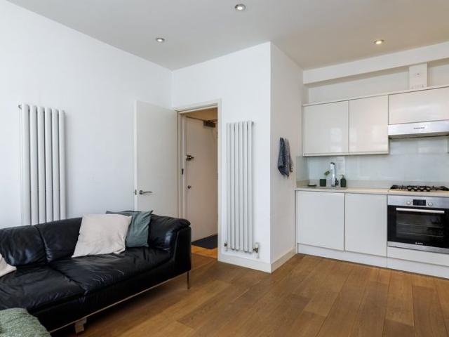 A smart refurbished apartment benefitting from wooden floors, open plan kitchen, bedroom with built in storage and a stylish bathroom