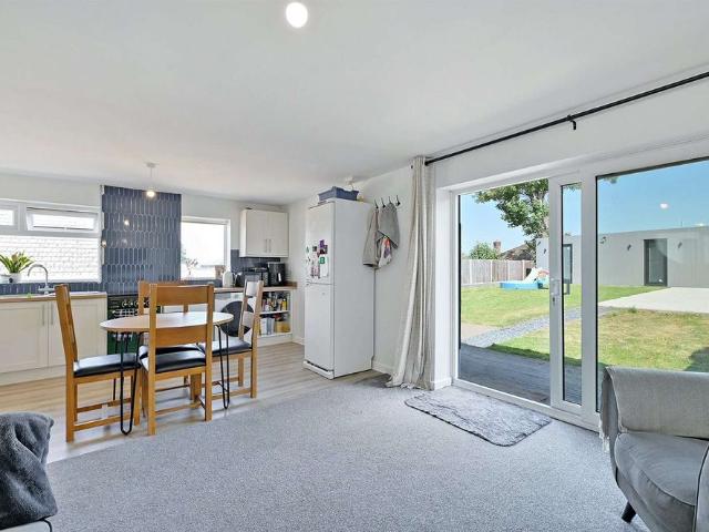 A well presented three bedroom home featuring an open plan reception room/kitchen, principal bedroom with ensuite, detached studio and office outbuilding, gardens, and off road parking
