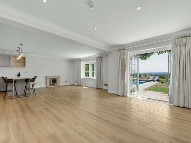 An attractive six bedroom family home set within mature grounds on the prestigious St George's Hill Estate, offering generous family accommodation, a swimming pool and far reaching views