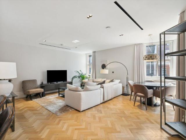 An elegant three bedroom lateral apartment positioned on the second floor of a prestigious Kensington mansion block