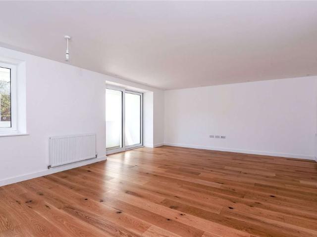 An immaculately presented two bedroom flat with a large kitchen/reception room offering flexible living space, wood flooring and access out onto the private balcony