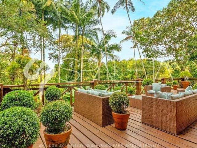 Aprecie o luxo e a tranquilidade no condomínio Iporanga, Guarujá: Casa exclusiva com ambientes espaç