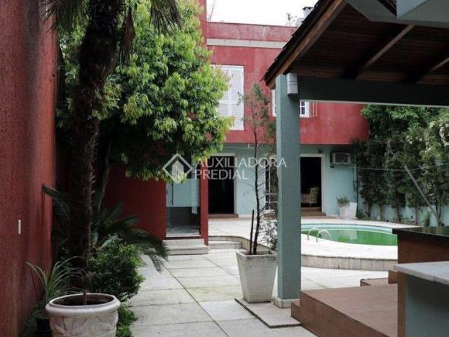 Casa ampla com peças bem distribuídas em rua calma, com piscina e churrasqueira