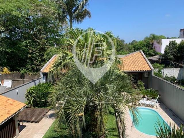 Casa com 3 dormitórios, suíte, quiosque, piscina e energia solar no Bairro Universitário, rua tranqu