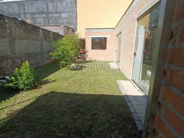 Casa com jardim amplo e árvores frutíferas.
