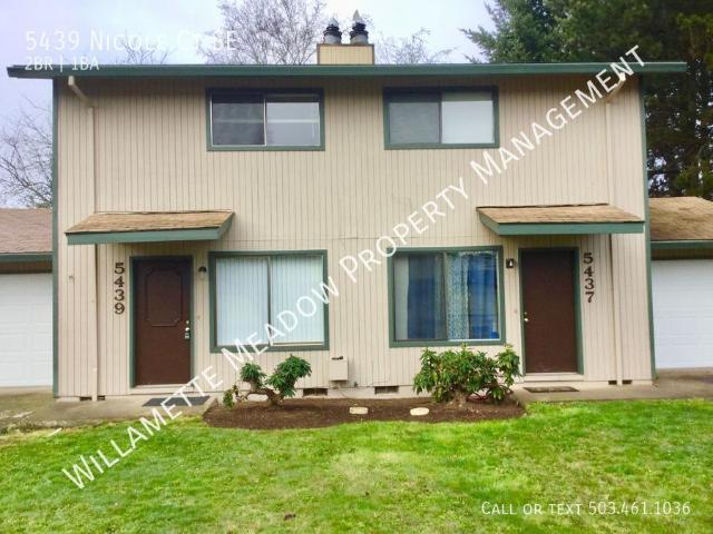 Charming 2 bedroom duplex with a fenced backyard, fireplace, and attached garage