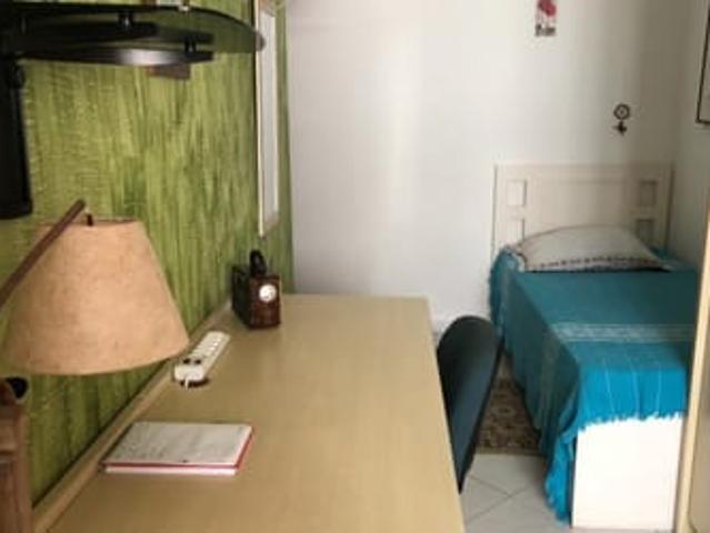 Quarto com bancada home office em apartamento tranquilo