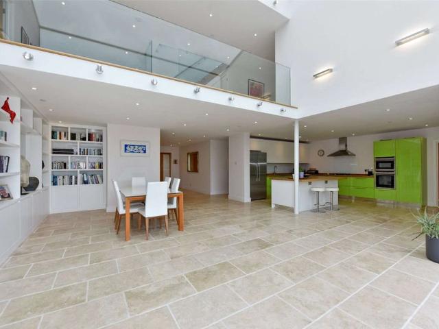 Stunning family home with a beautiful open plan kitchen and dining area, centred around a striking double height glass feature wall that floods the space with natural light